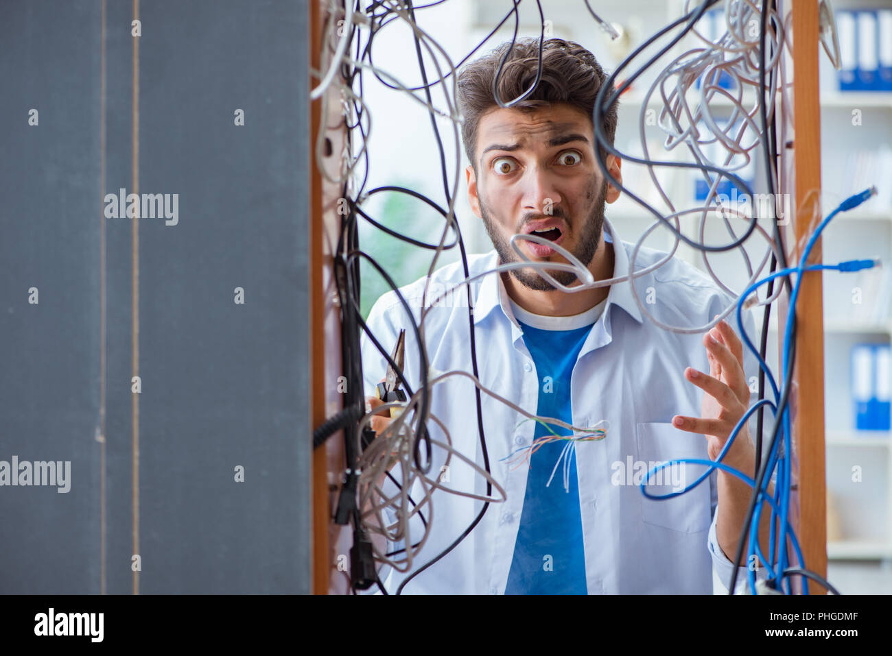 Electrician trying to untangle wires in repair concept Stock Photo - Alamy
