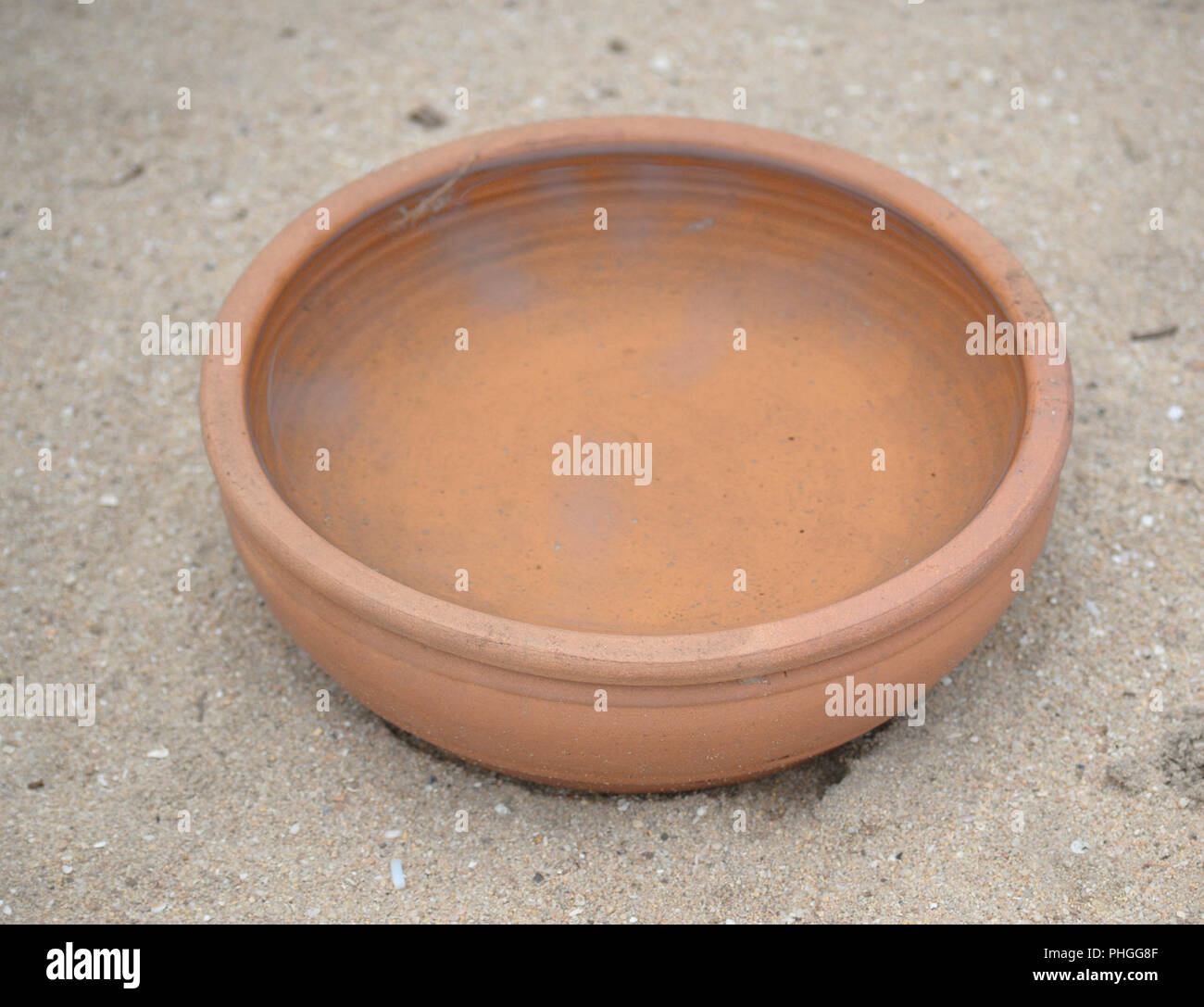 Clay pot on sand Stock Photo - Alamy