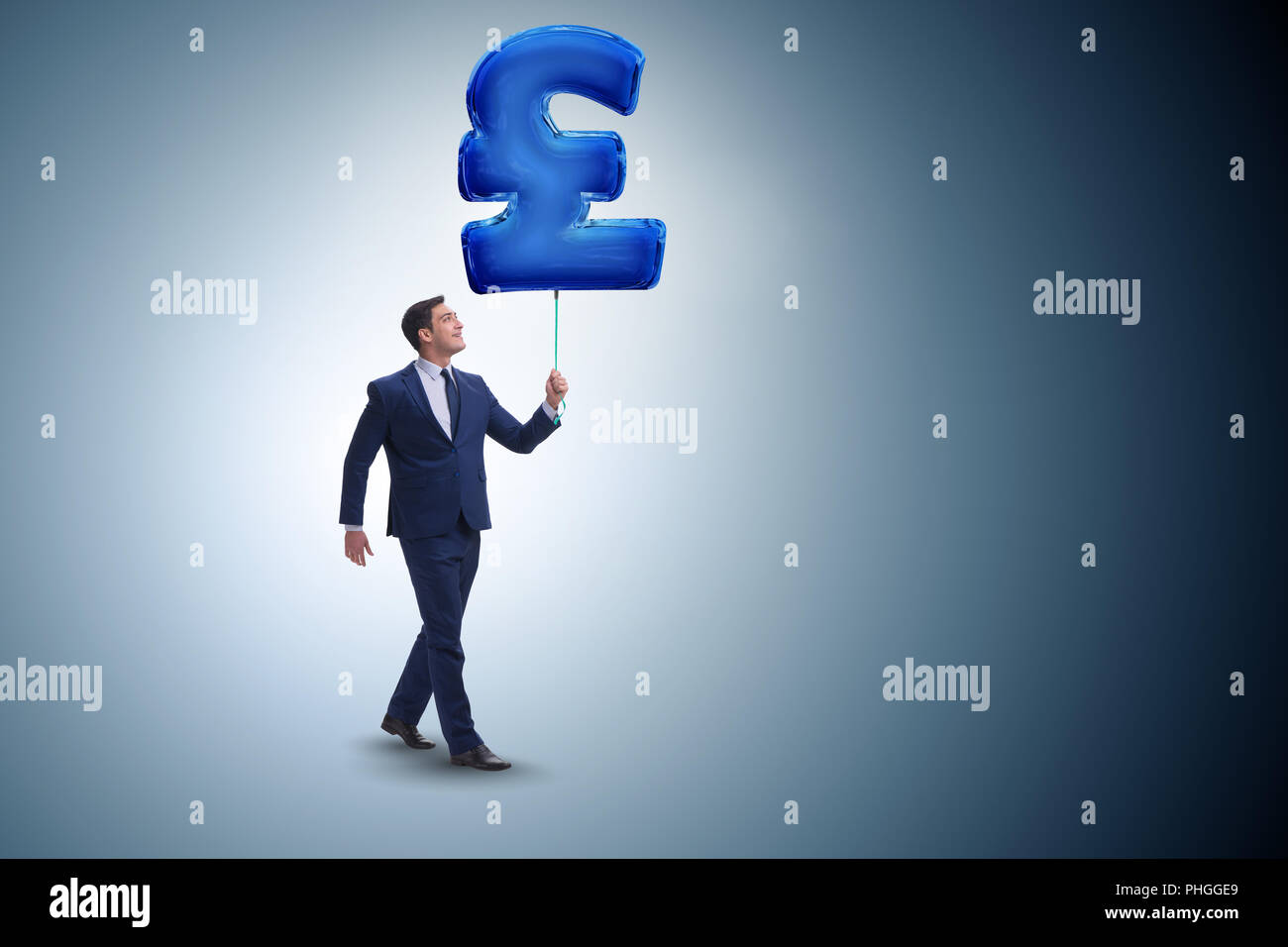 Businessman walking with inflatable british pound sign Stock Photo - Alamy