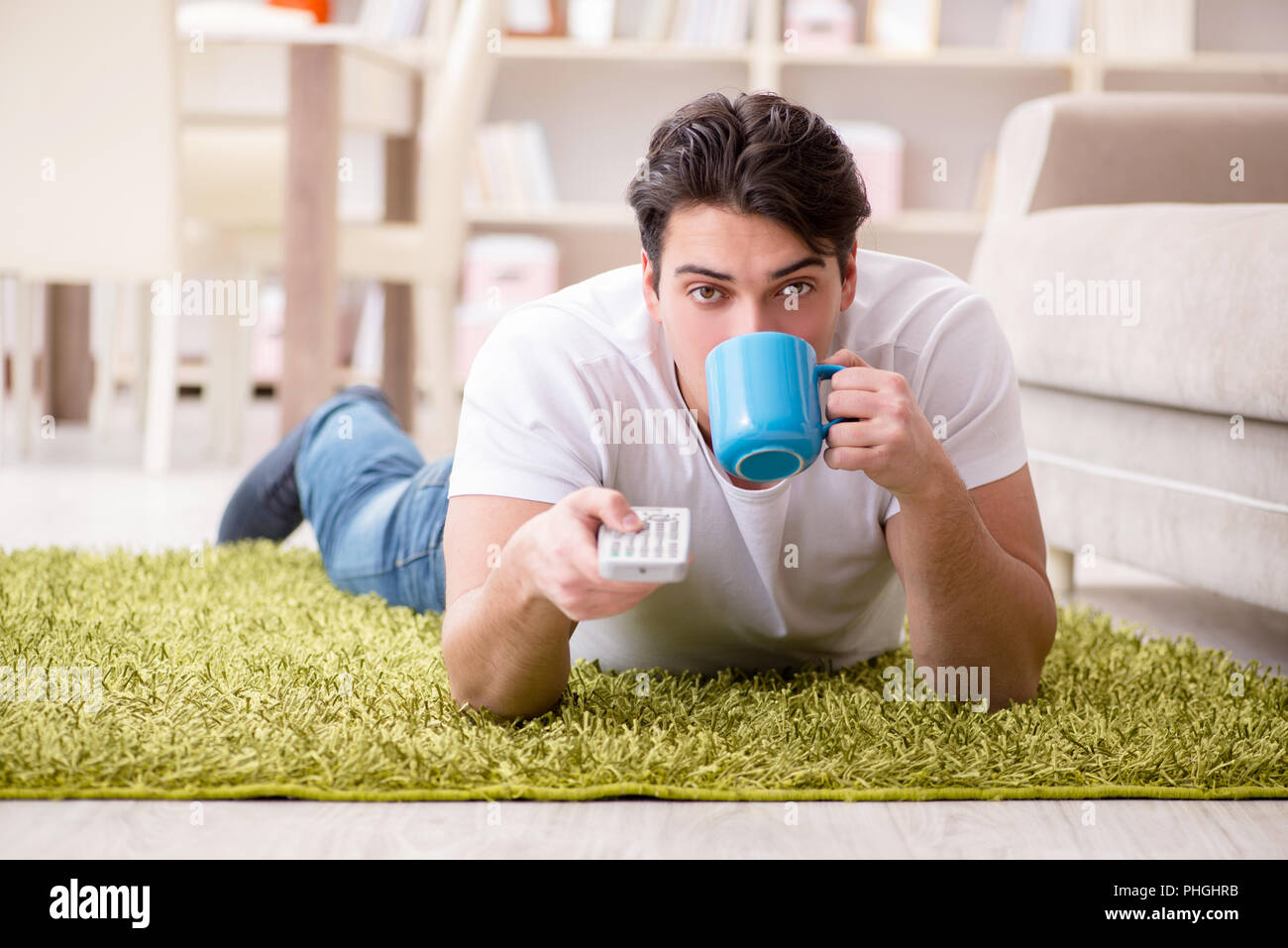 Man watching tv at home on floor Stock Photo - Alamy