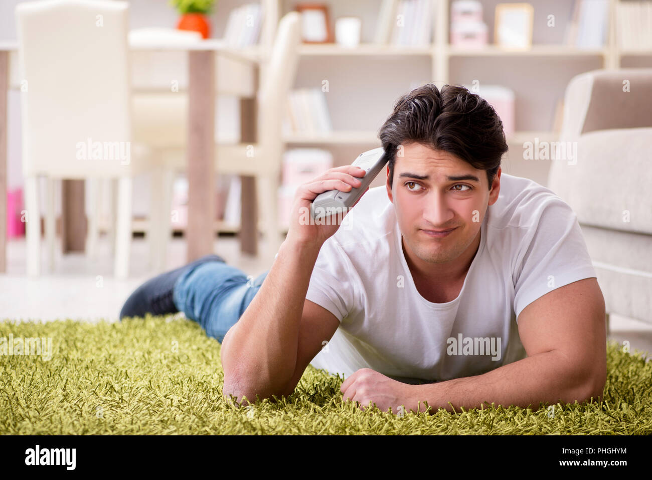 Man watching tv at home on floor Stock Photo - Alamy