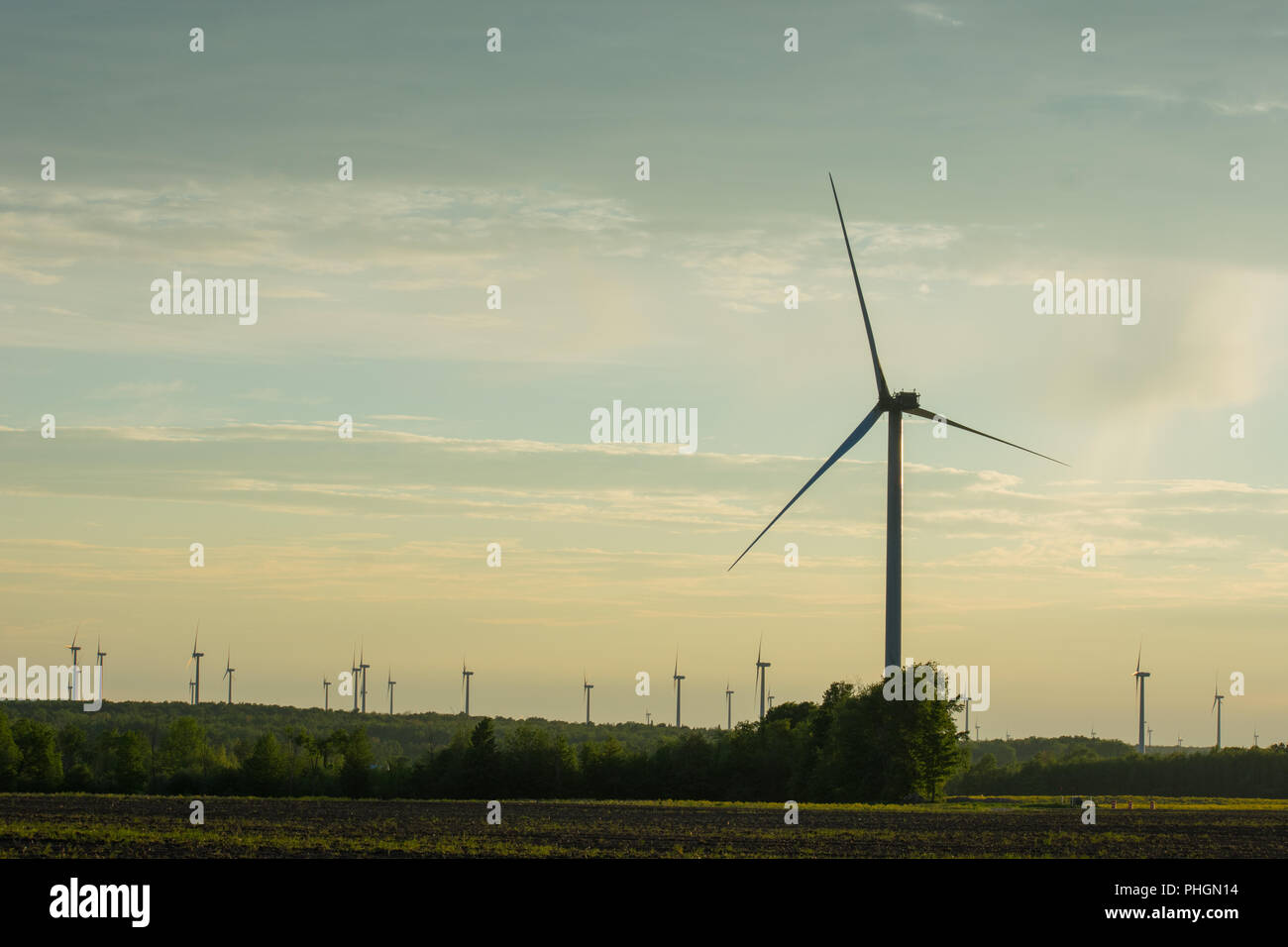 A windmill farm at sunset in a rural area Stock Photo - Alamy