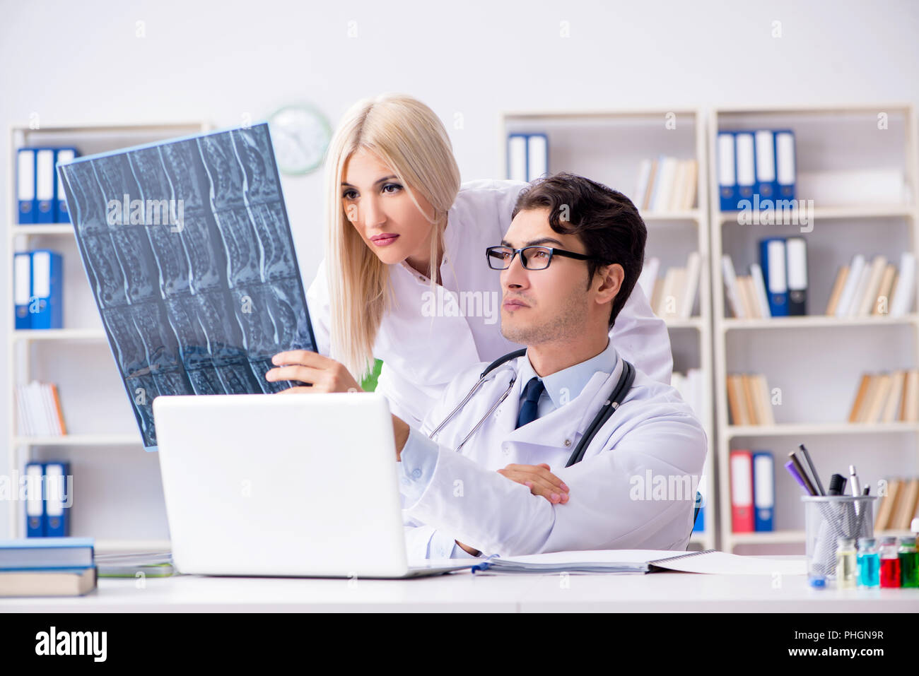 Two doctors examining x-ray images of patient for diagnosis Stock Photo ...