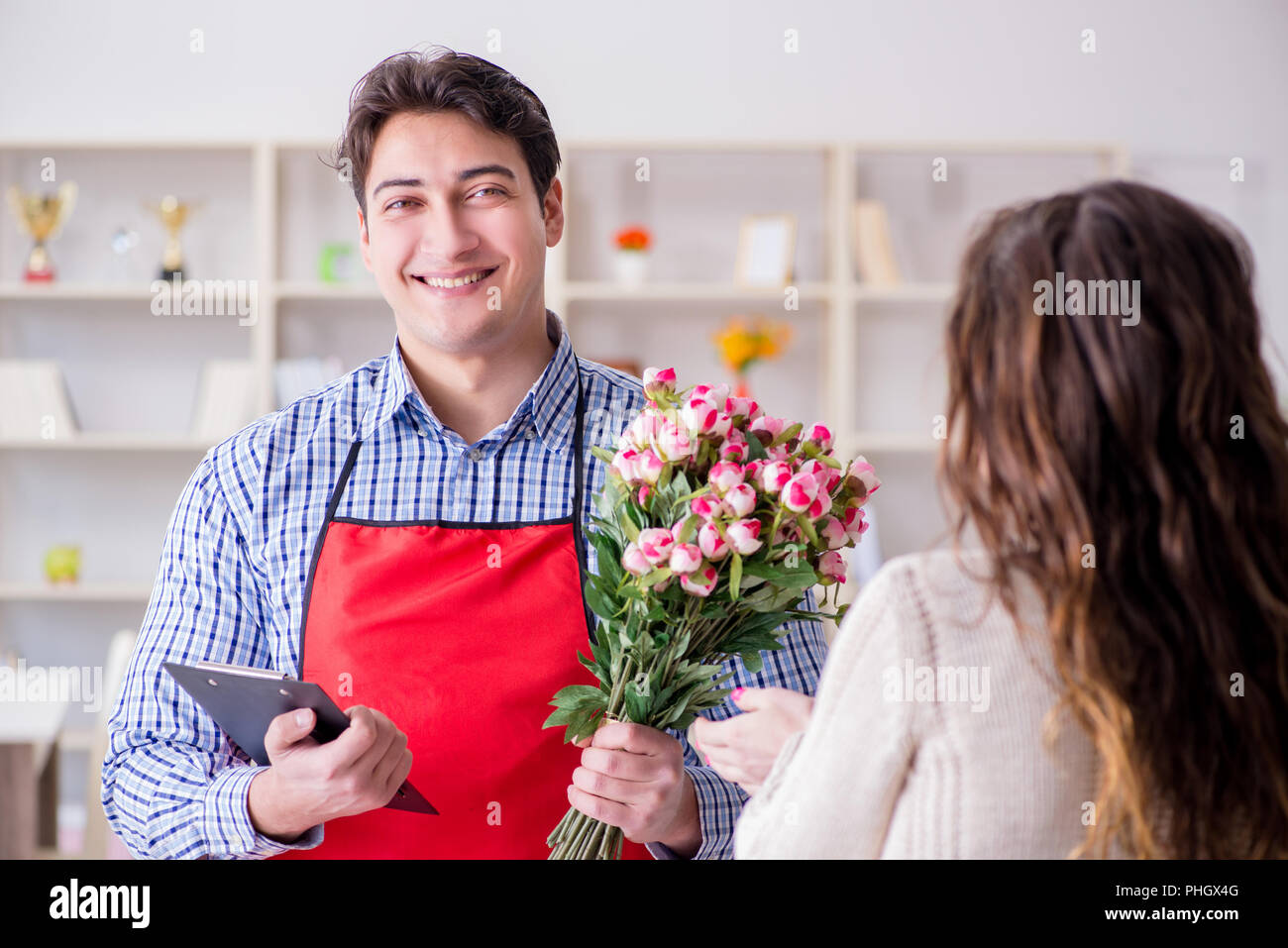 Flower shop assistant selling flowers to female customer Stock Photo ...