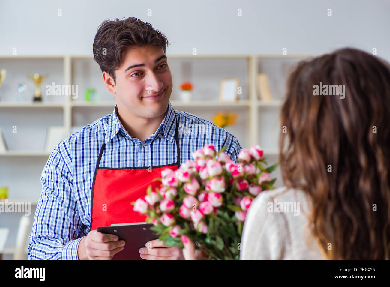 Flower shop assistant selling flowers to female customer Stock Photo ...