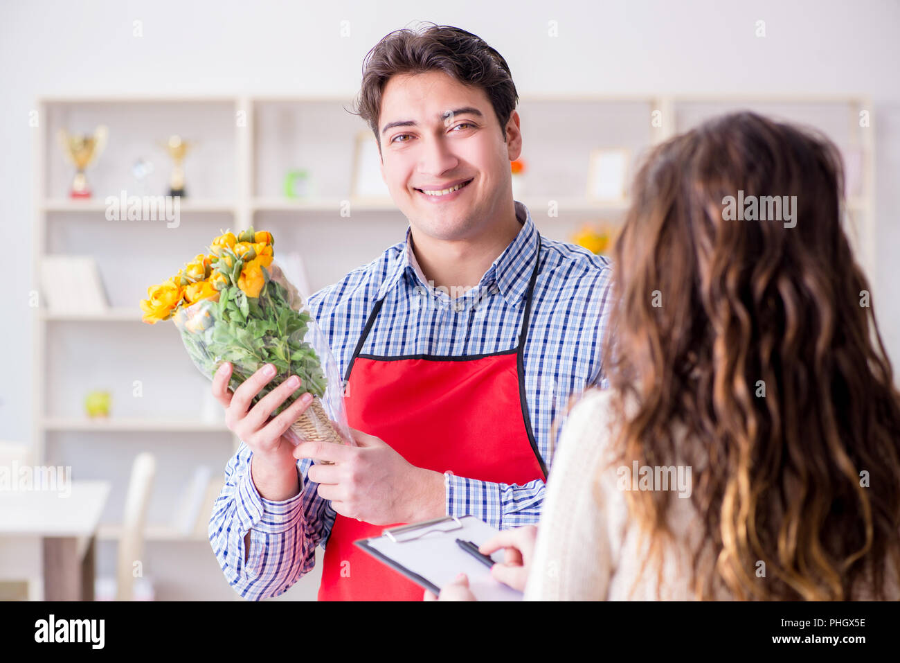 Flower shop assistant selling flowers to female customer Stock Photo ...