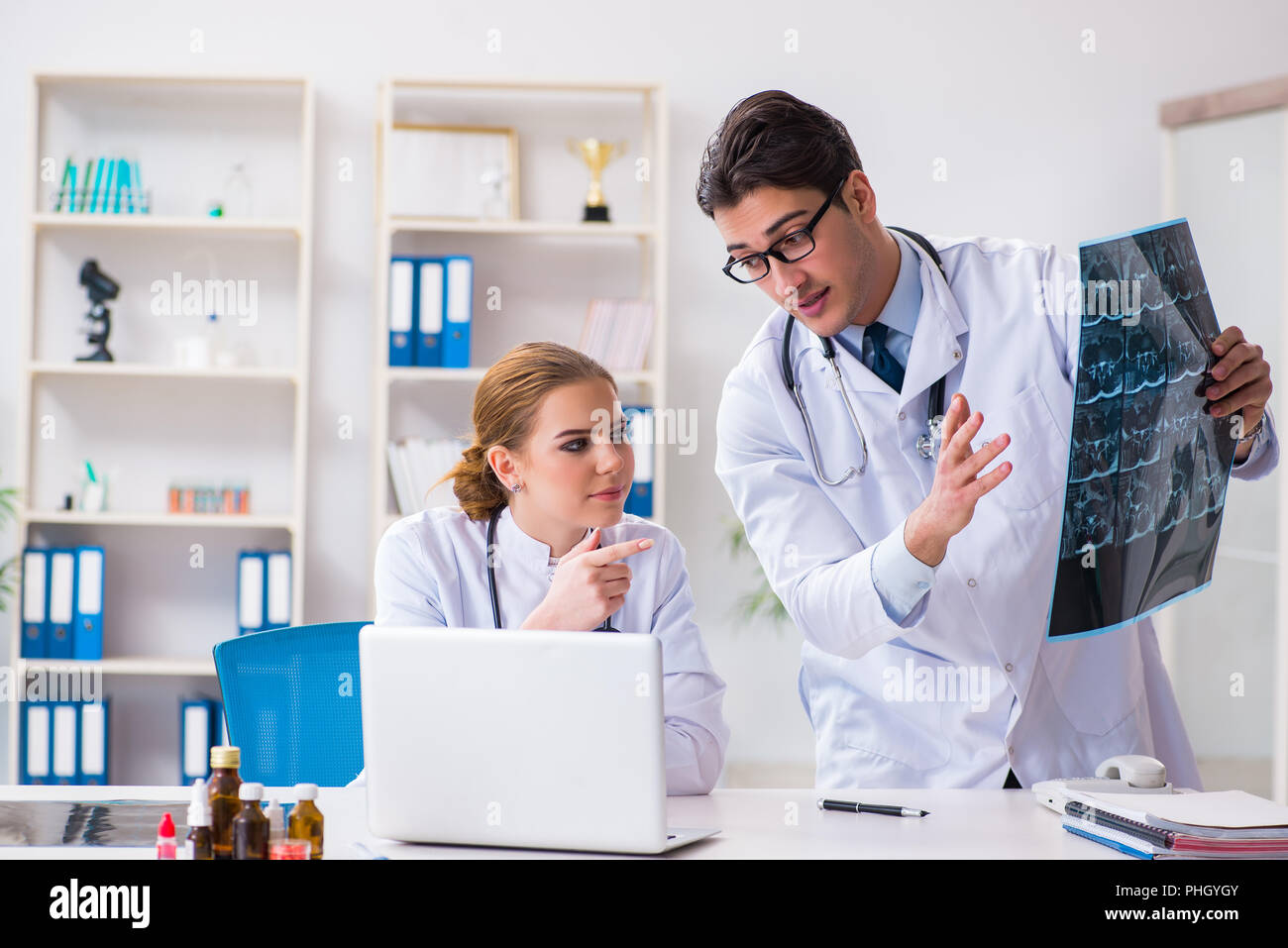 Two doctors examining x-ray images of patient for diagnosis Stock Photo ...