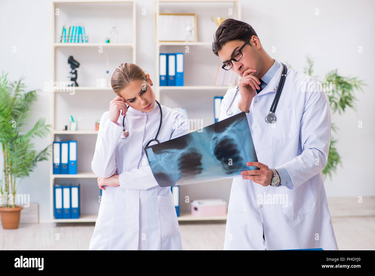 Two doctors examining x-ray images of patient for diagnosis Stock Photo ...