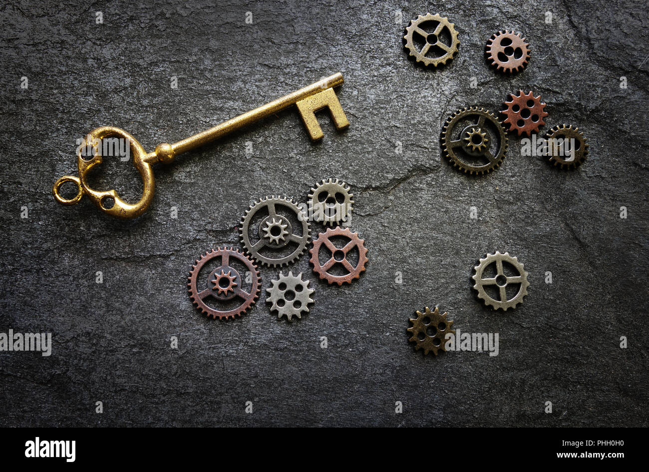 Gold key with gears Stock Photo - Alamy