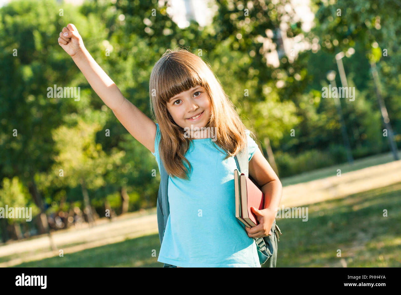 Cheerful schoolgirl holding book hi-res stock photography and images ...