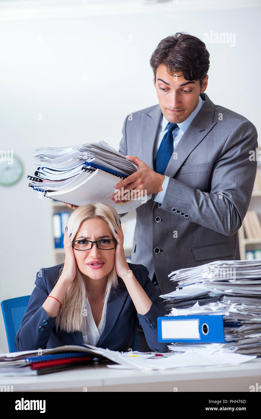 Boss bringing additional work to his assistant secretary Stock Photo ...