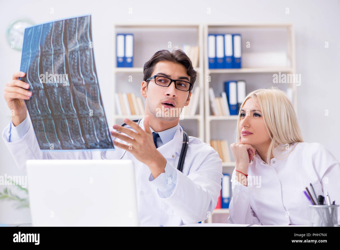 Two doctors examining x-ray images of patient for diagnosis Stock Photo ...