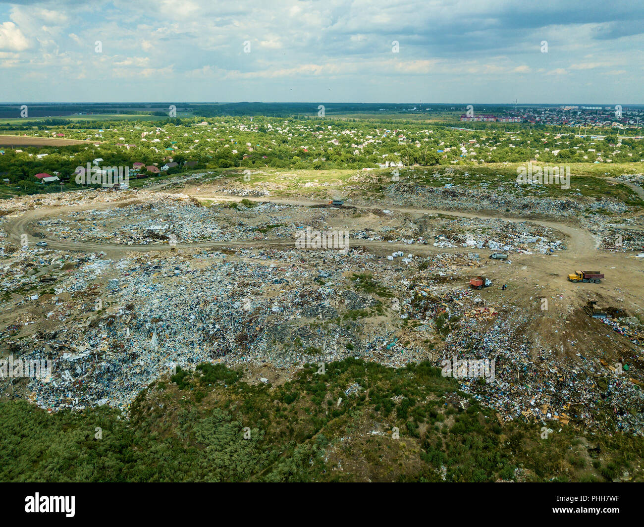At a municipal landfill, a bulldozer tractor pushes garbage from a ...