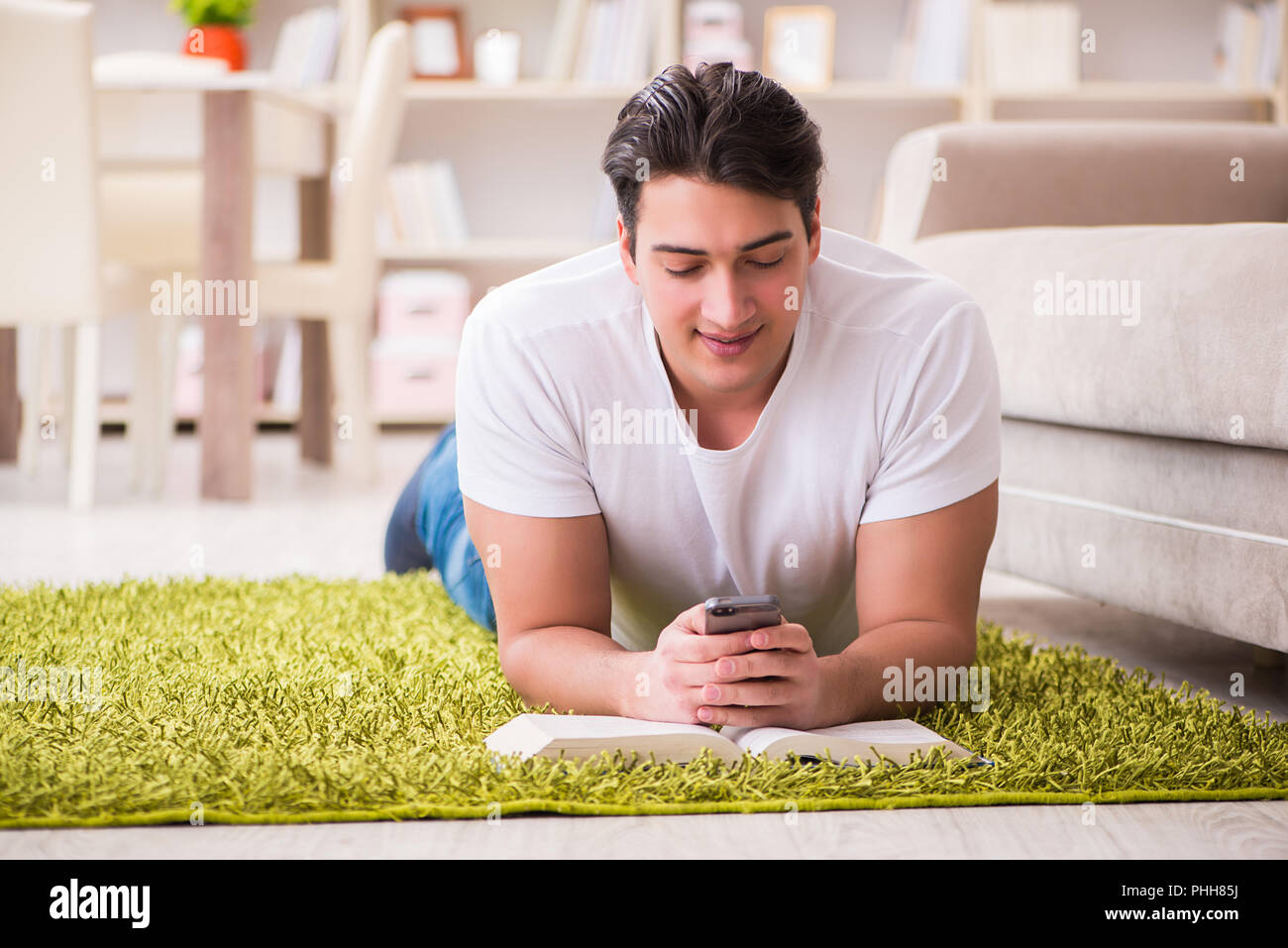 Man reading book at home on floor Stock Photo - Alamy