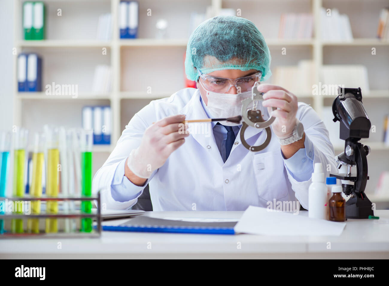 Criminologist police chemist looking at crime evidence Stock Photo - Alamy