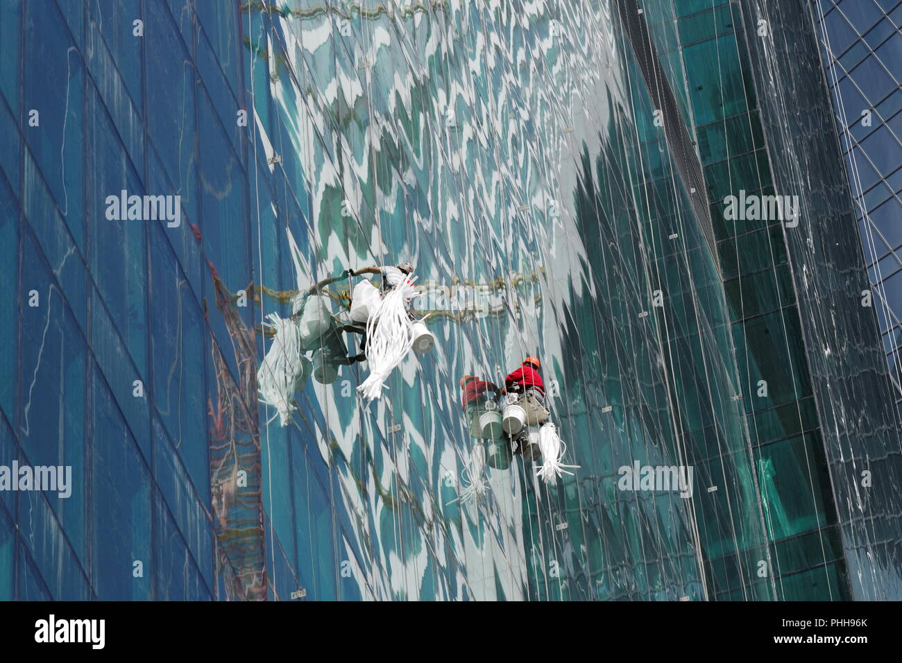 Windows washers cleaning glass facade of a high rise building Stock ...