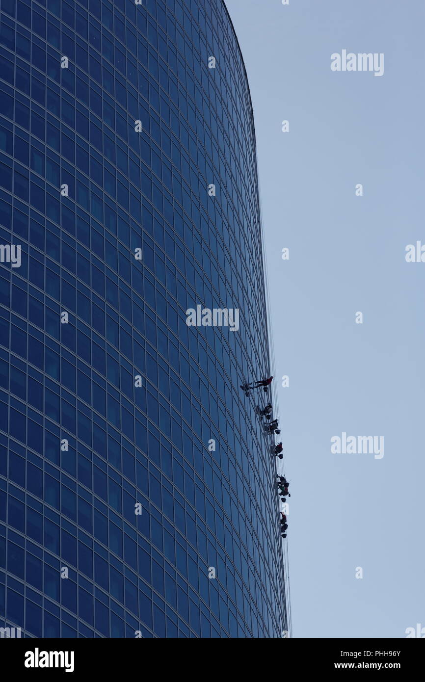 Windows washers cleaning glass facade of a high rise building Stock ...