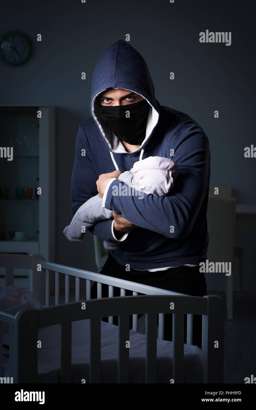 Criminal stealing baby in human child traficking concept Stock Photo ...