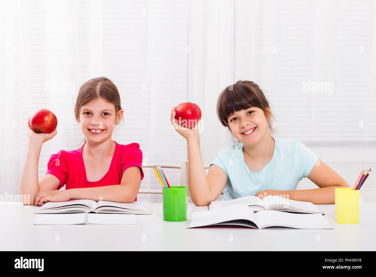 Cute little girls are having healthy snack while they are doing ...