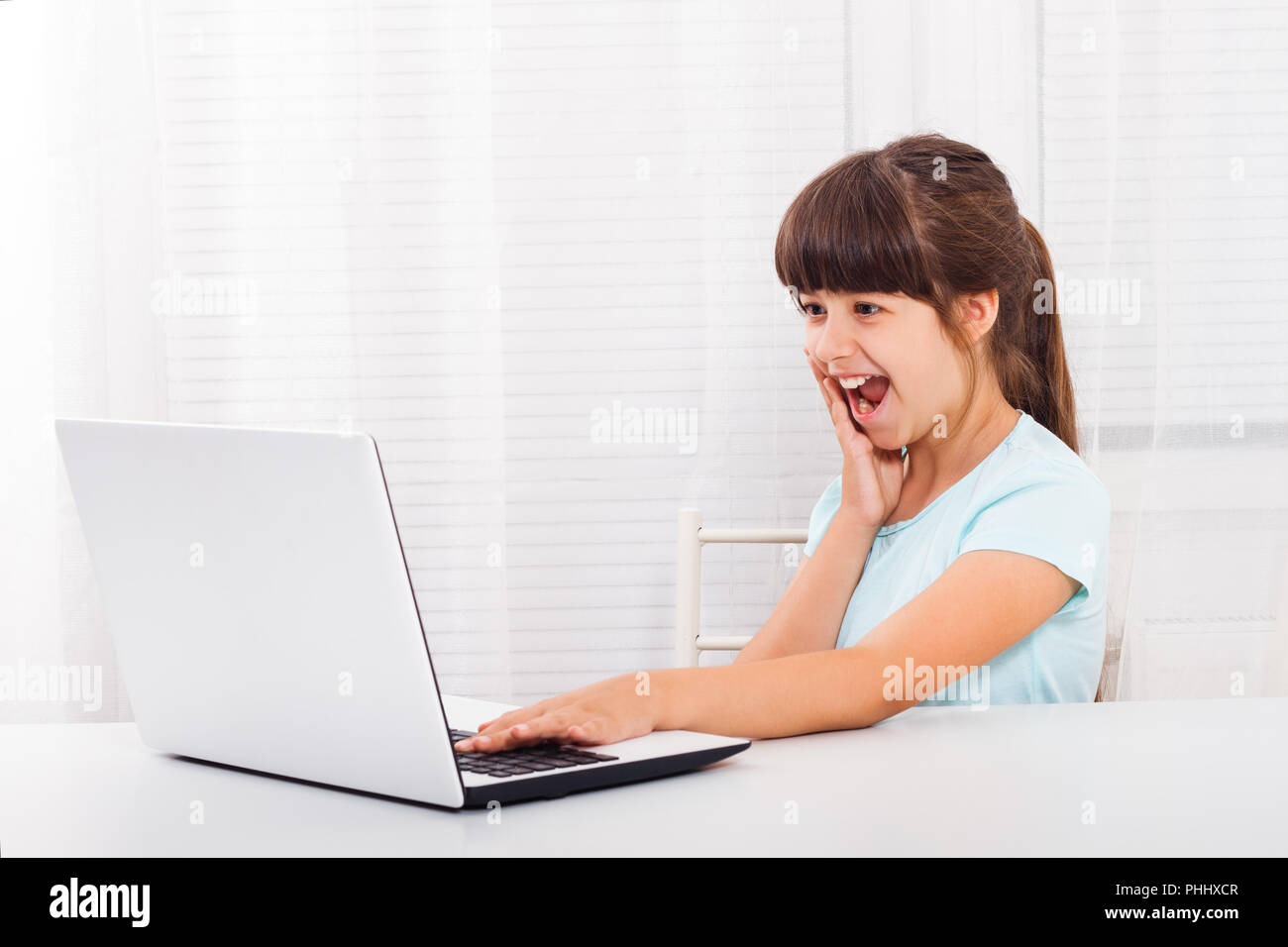Excited little girl using laptop Stock Photo - Alamy