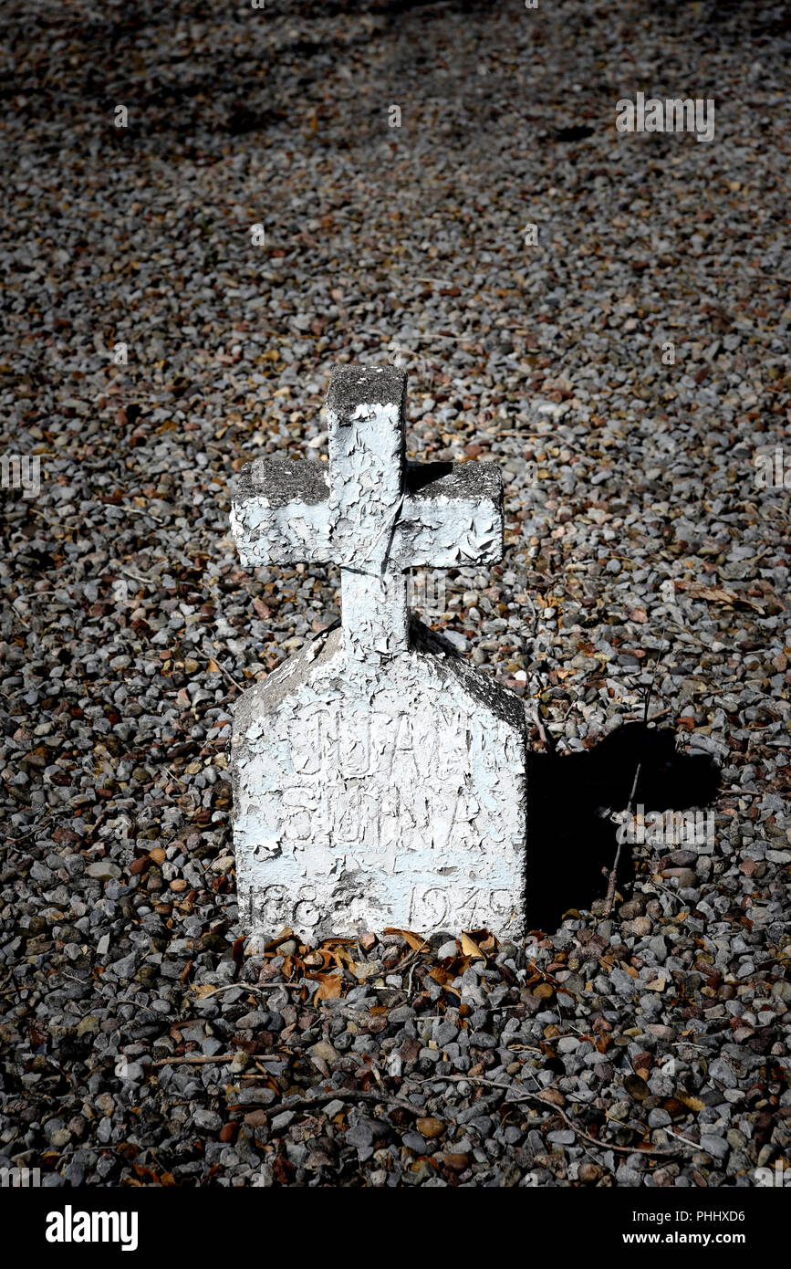 A weathered homemade cement cross and grave marker in a cemetery in New ...
