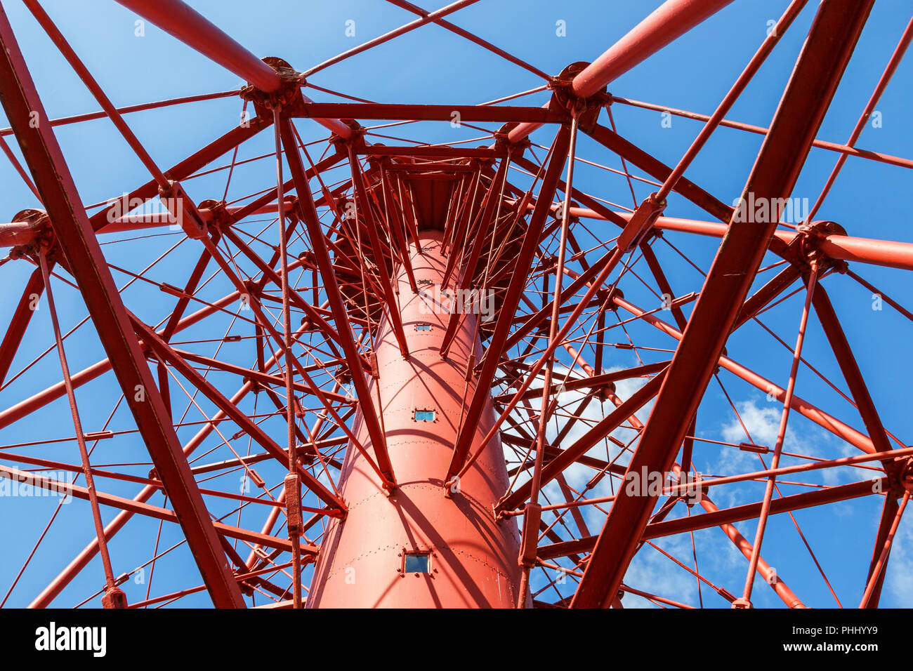 Red cast iron lighthouse against a blue sky from below Stock Photo - Alamy
