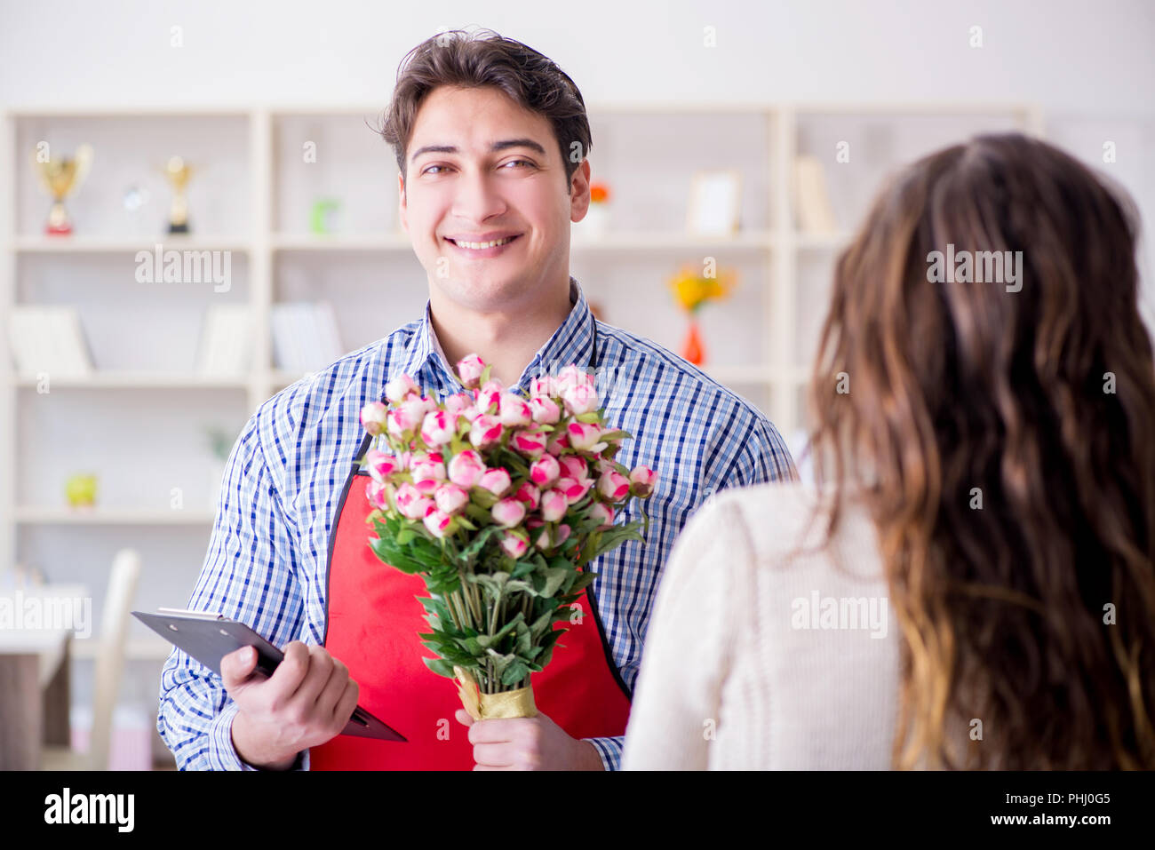 Flower shop assistant selling flowers to female customer Stock Photo ...