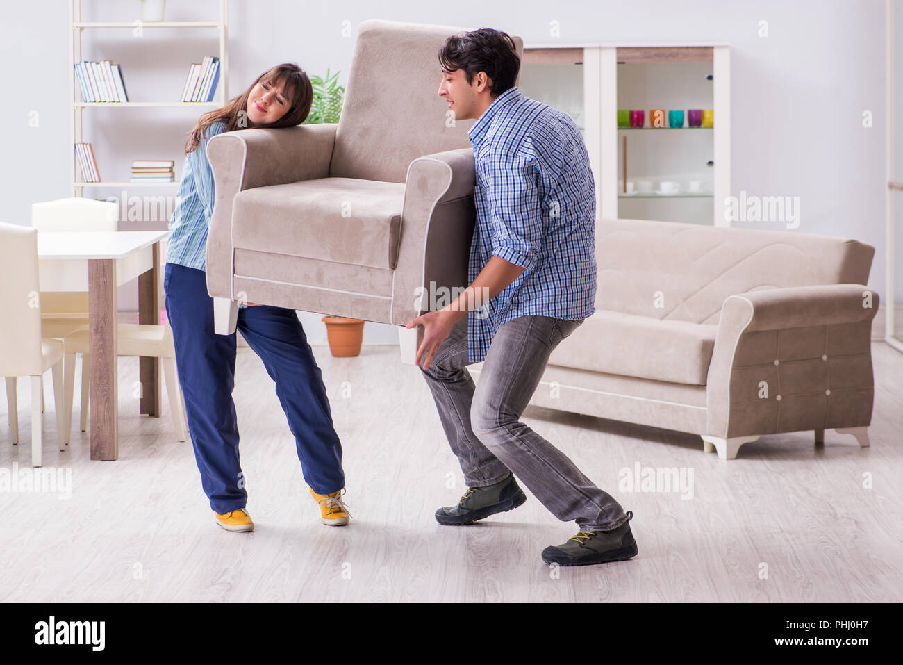 Man moving armchair in the living room Stock Photo - Alamy