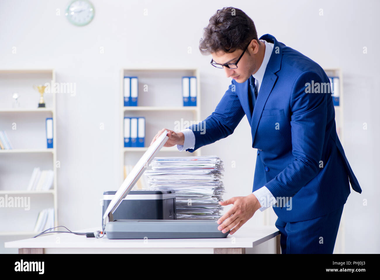 Businessman making copies in copying machine Stock Photo - Alamy