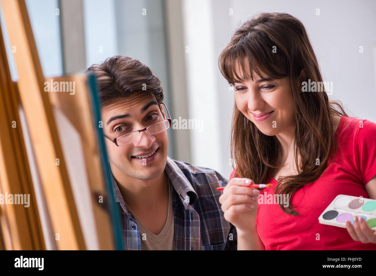 Artist coaching student in painting class in studio Stock Photo - Alamy