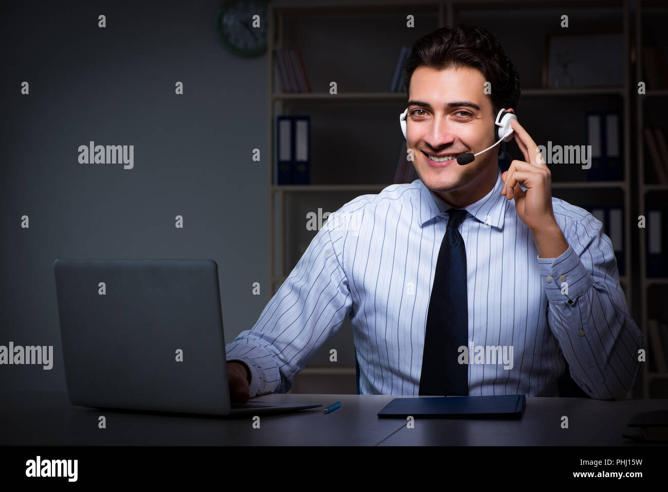 Call center operator talking to customer during night shift Stock Photo ...