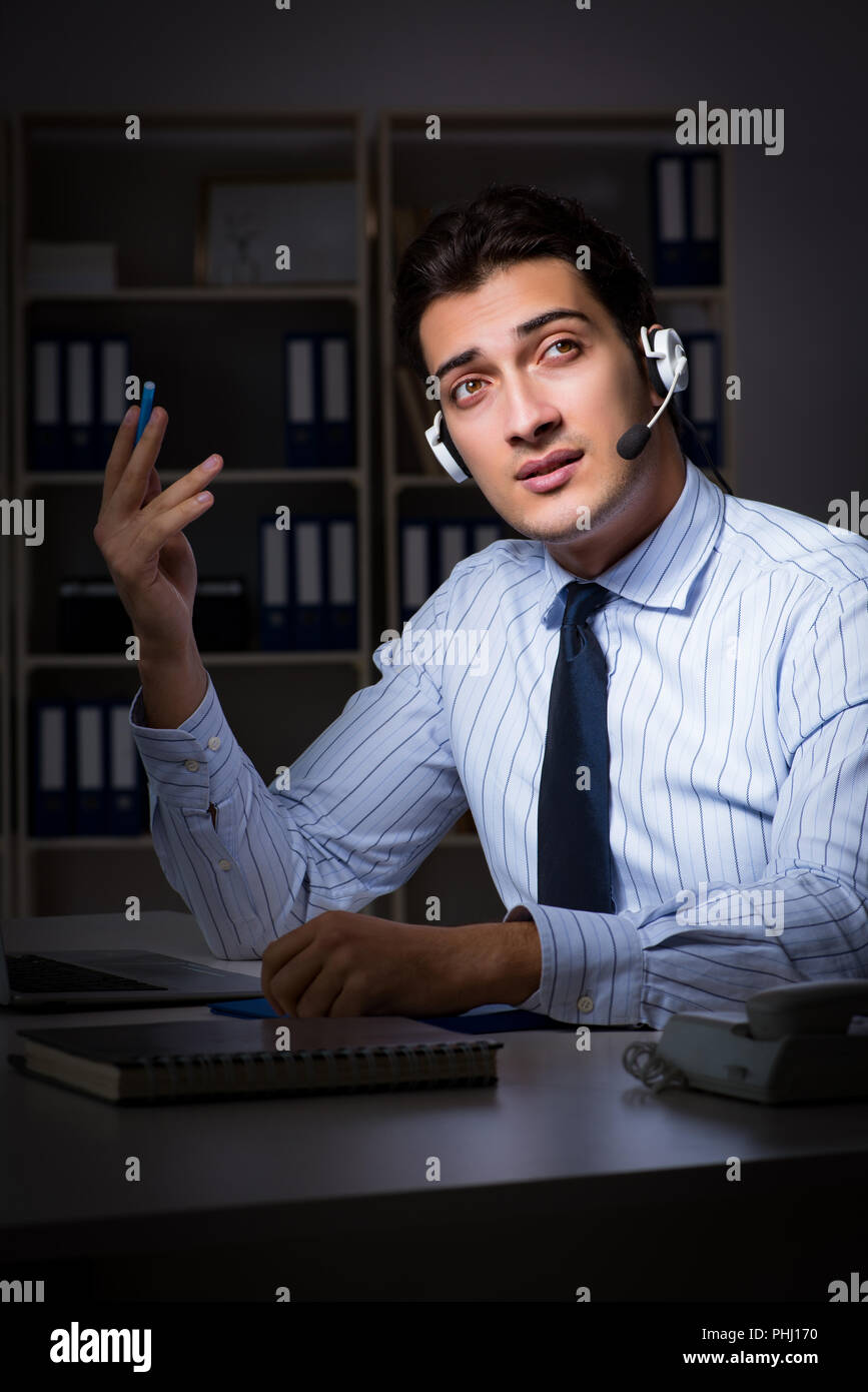 Call center operator talking to customer during night shift Stock Photo ...