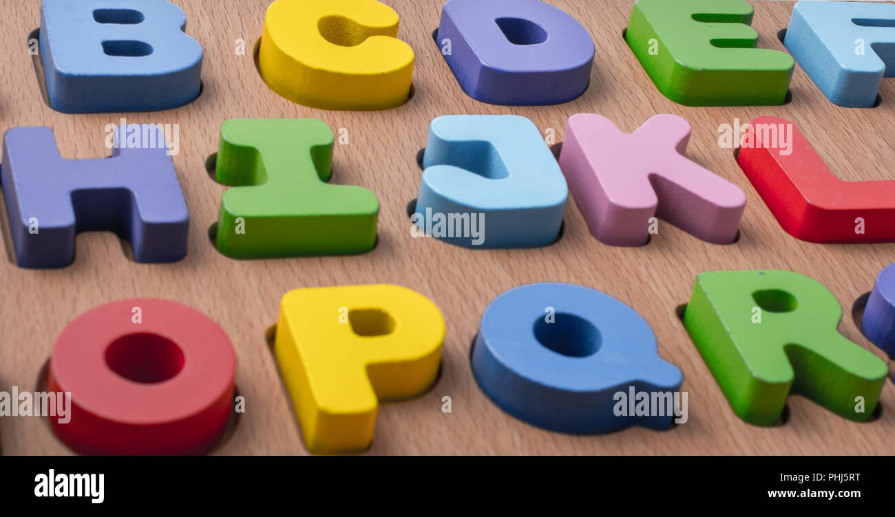 Colorful letter blocks on board on white background Stock Photo - Alamy