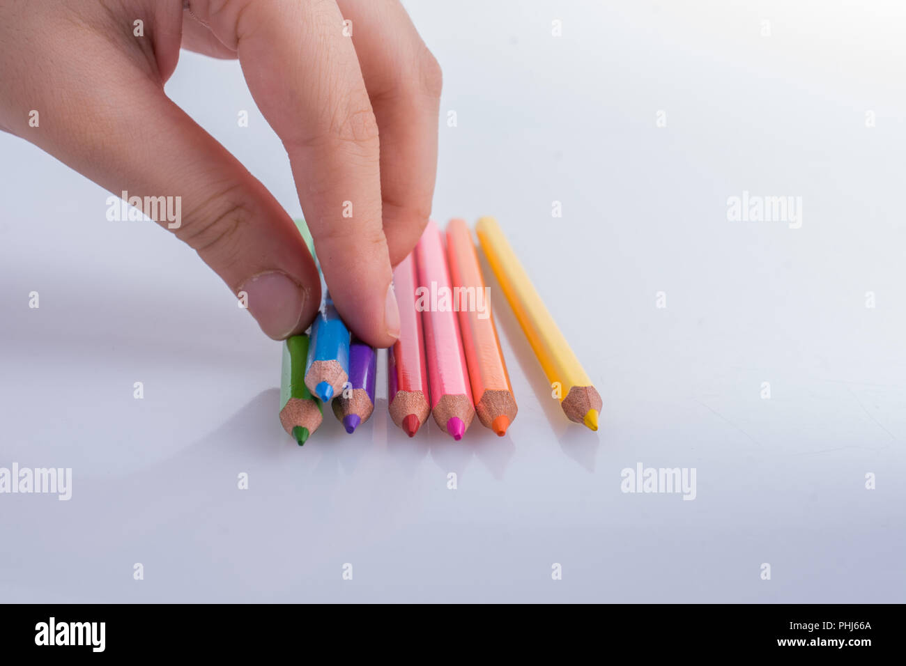Hand holding color Pencils placed on a white background Stock Photo - Alamy