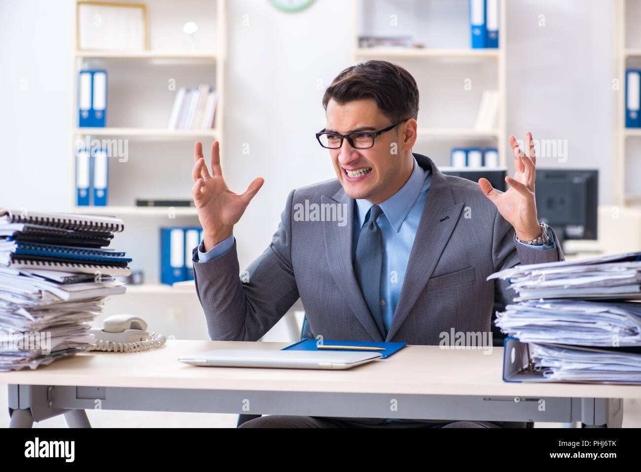 Overloaded with work employee under paperwork burden Stock Photo - Alamy