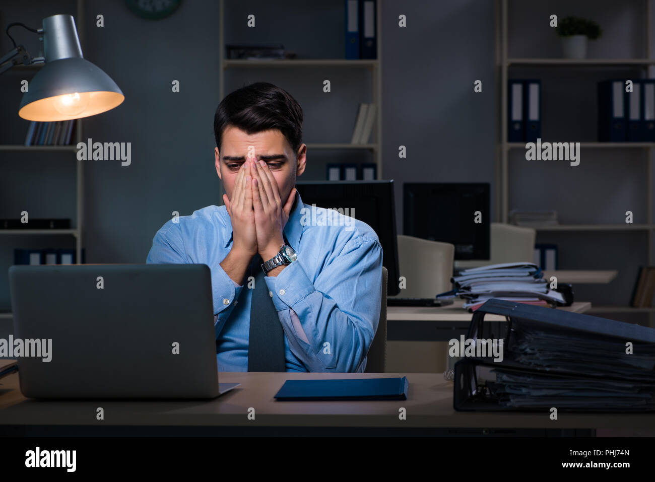 Employee working late at night at important report Stock Photo - Alamy