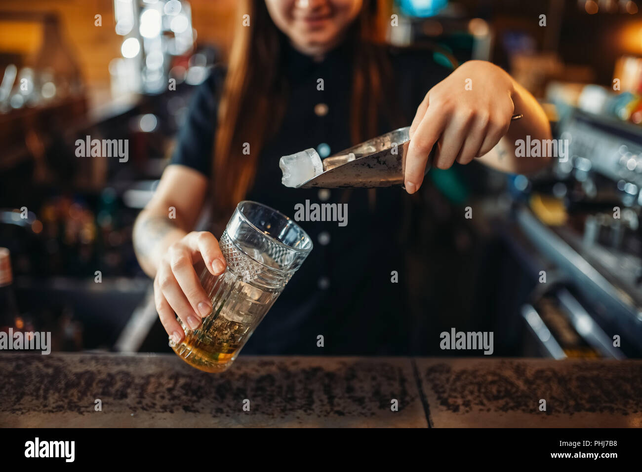 Female barman mixing at the bar counter in pub. Woman bartender ...