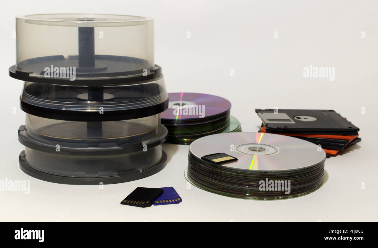 data storages still-life: floppy disks, stack of compact disks and ...