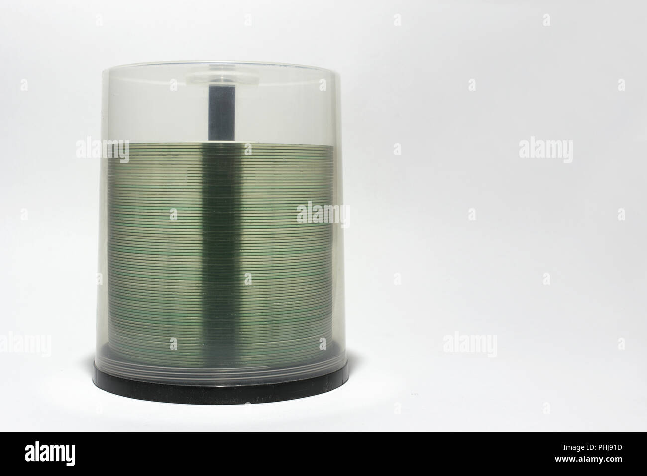 transparent rim of cds in stack. plastic storage tube with blurry ...