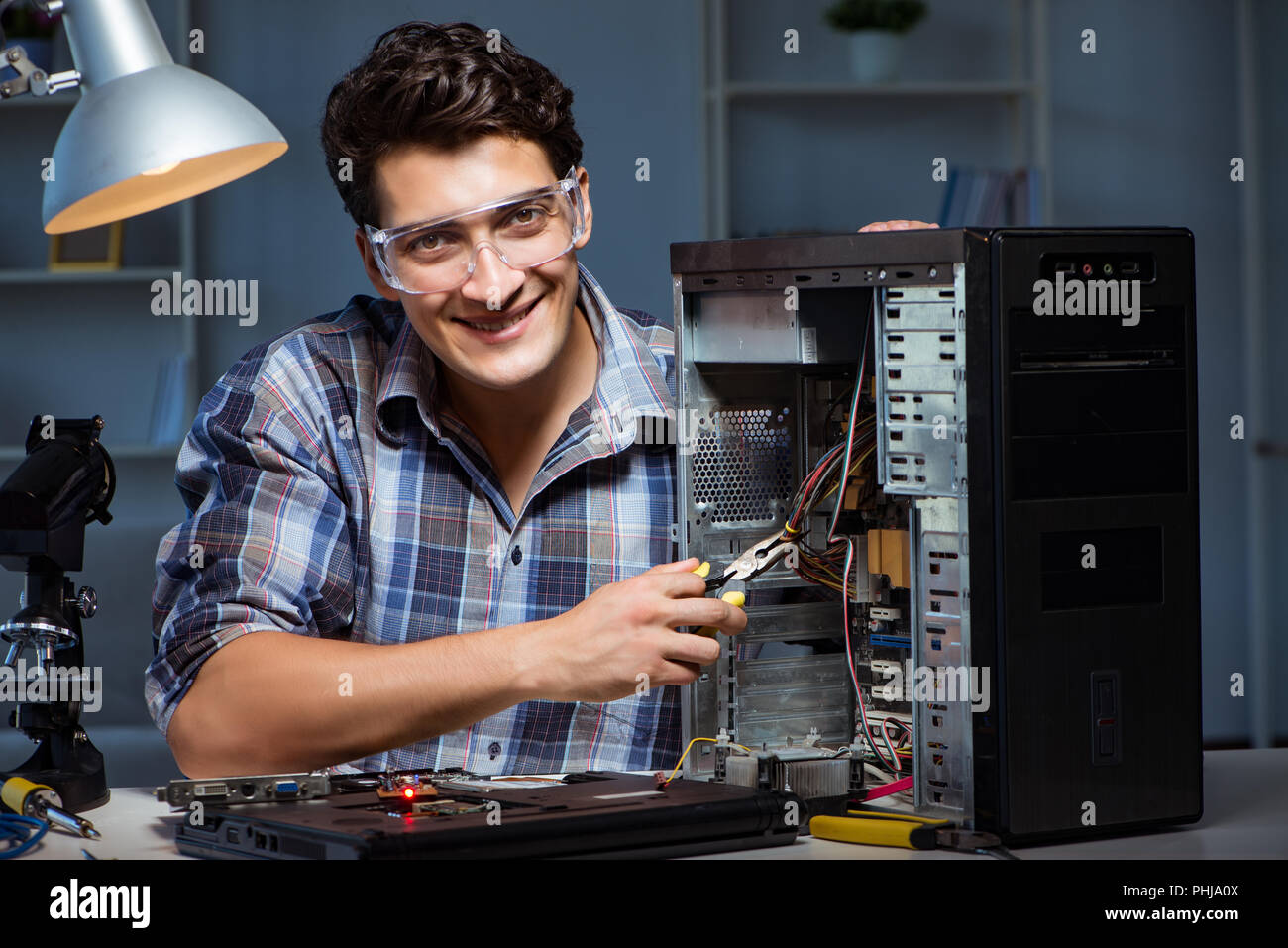 Man repairing computer desktop with pliers Stock Photo - Alamy