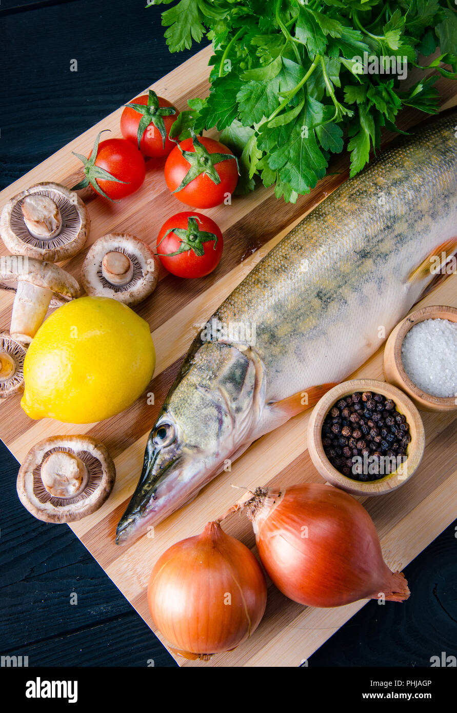 Uncooked fish on cutting board in meal preparation concept Stock Photo ...