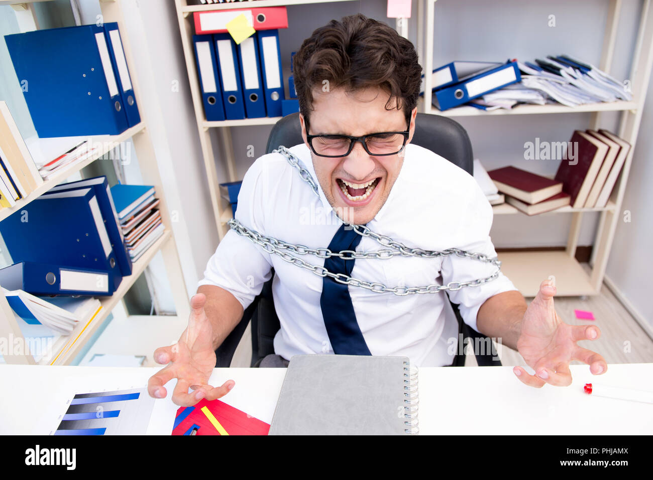 Employee attached and chained to his desk with chain Stock Photo - Alamy