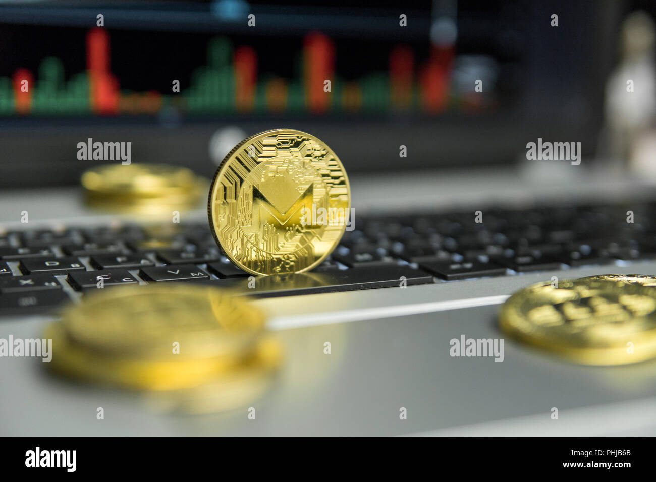 Golden Monero coin with gold coins lying around on a black keyboard of ...