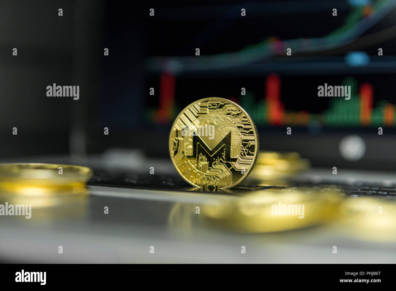 Golden Monero coin with gold coins lying around on a black keyboard of ...