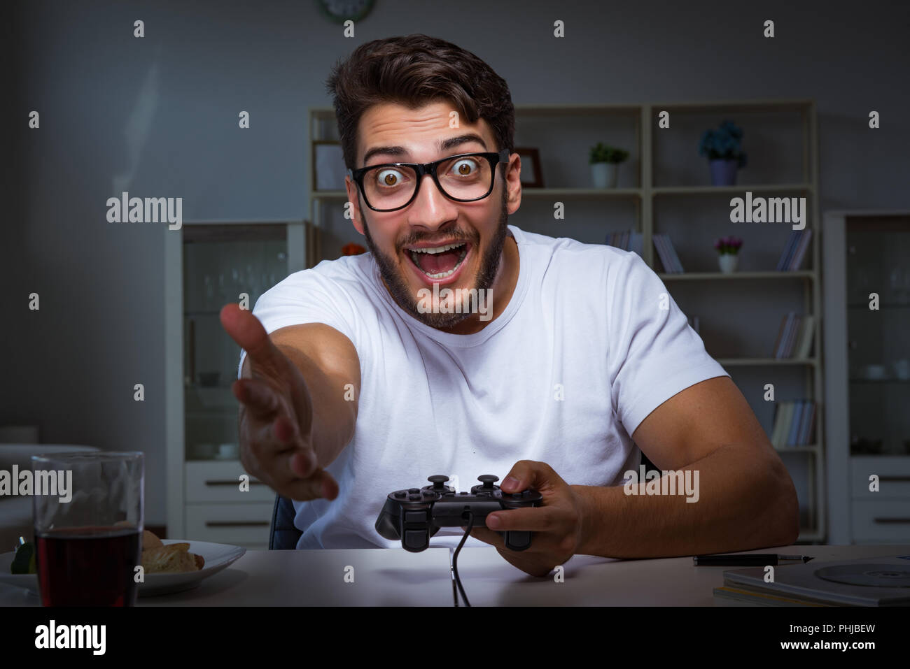 Young man playing games long hours late in the office Stock Photo - Alamy
