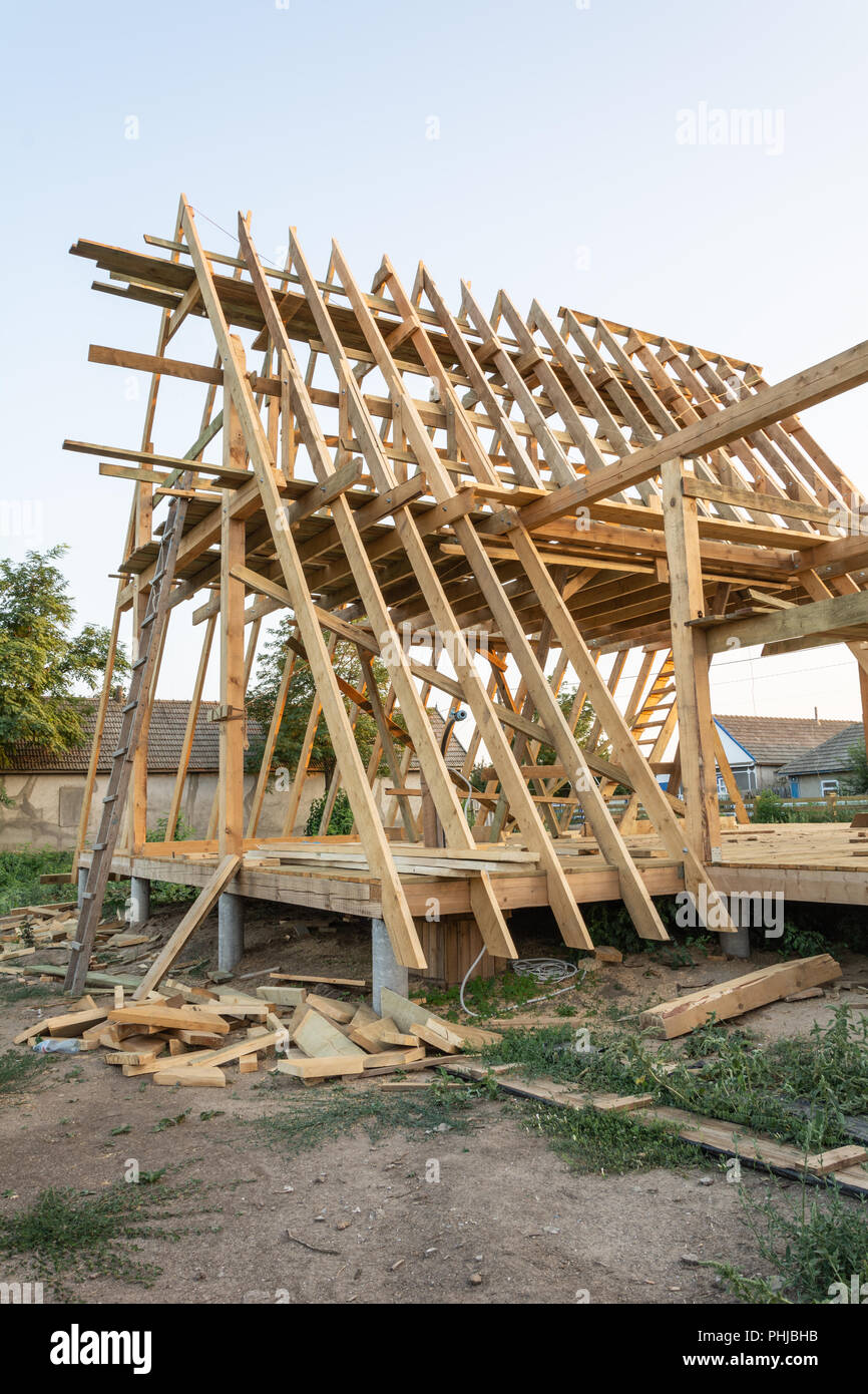 Wooden rafters of a new home under construction at sunset. New house ...