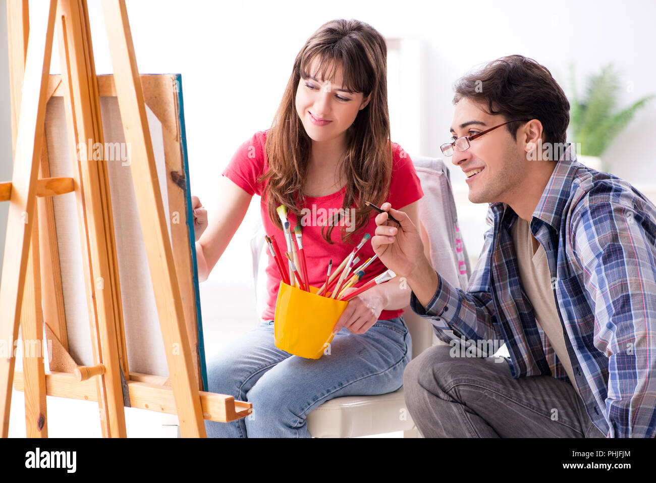 Artist coaching student in painting class in studio Stock Photo - Alamy