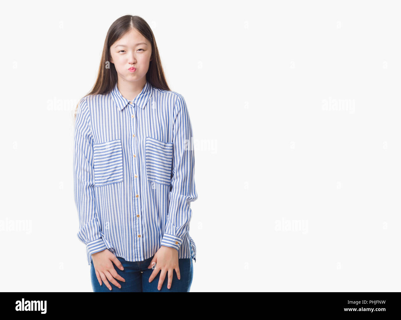 Young Chinese woman over isolated background puffing cheeks with funny ...