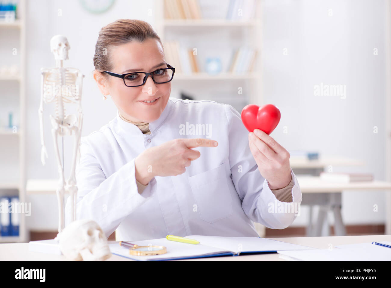 Cardiologist with red heart in medical concept Stock Photo - Alamy