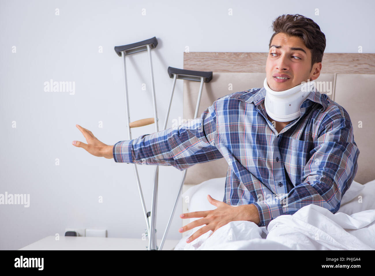 Injured man in bed at home with crutches Stock Photo - Alamy